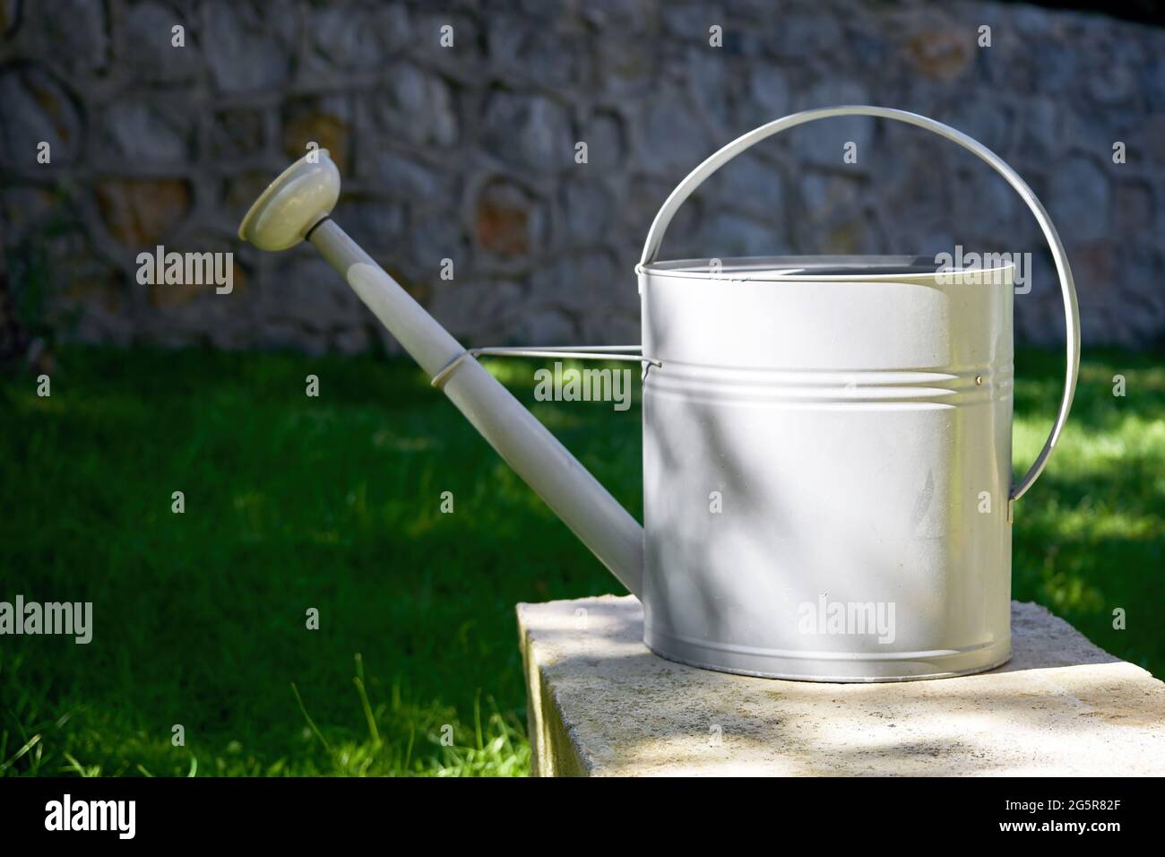 Metal watering pot with garden, grass and wall background. Gardening ...