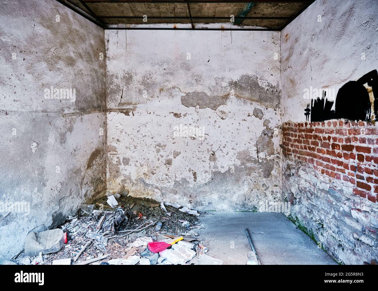 Interior of an abandoned ruin room with cracked walls and trash on the ...