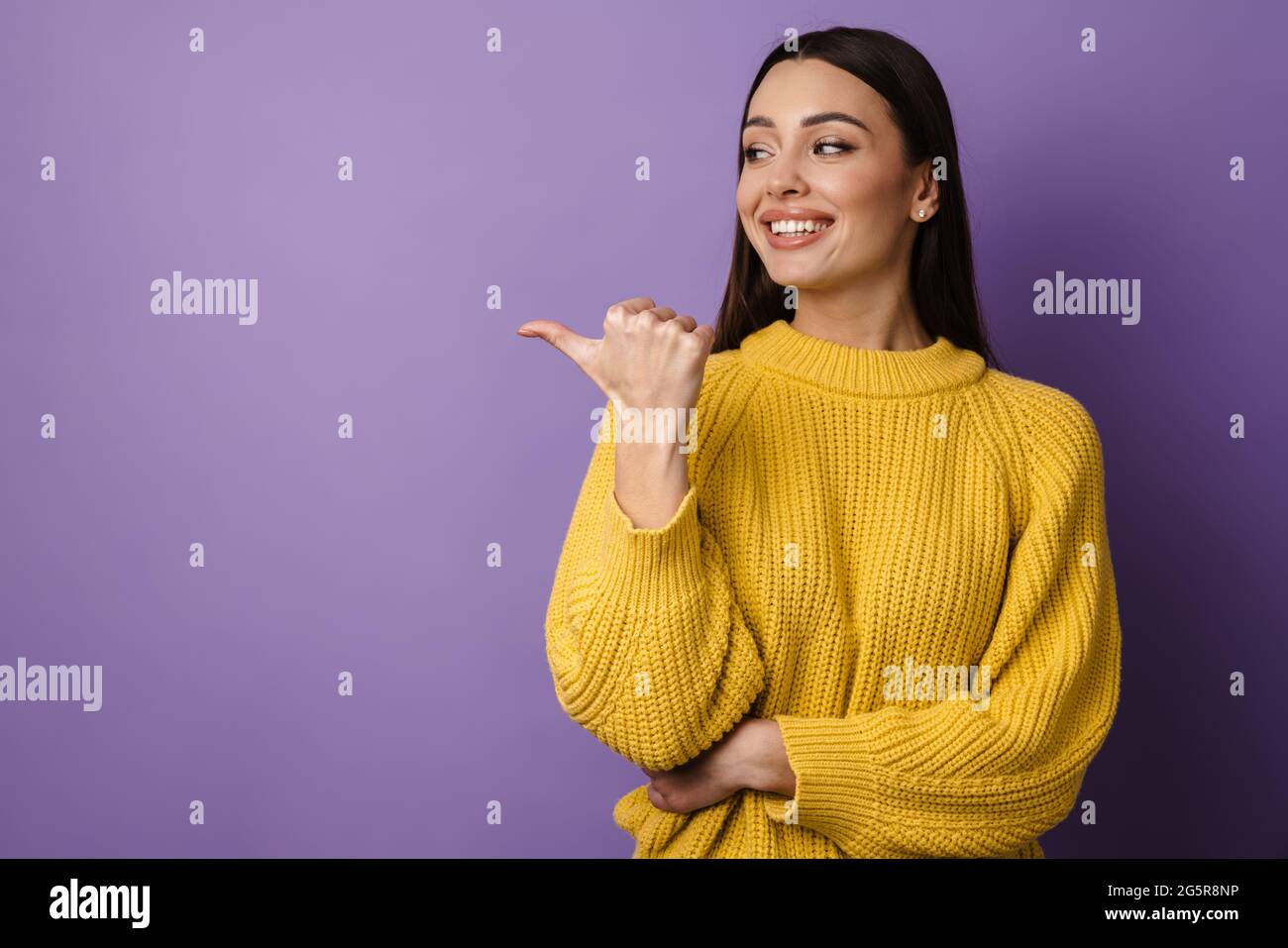Happy nice girl smiling while pointing finger aside isolated over ...