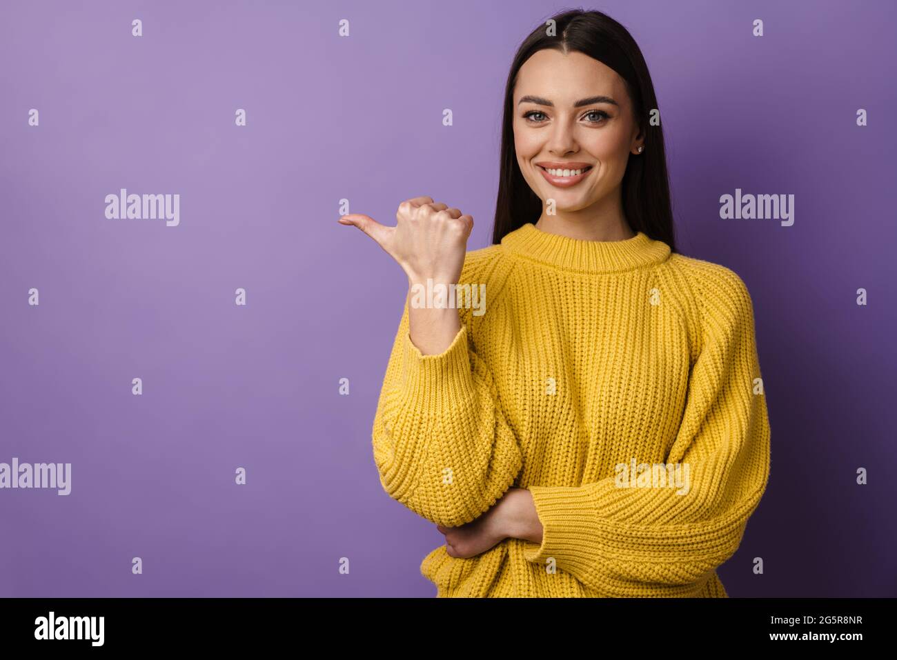 Happy nice girl smiling while pointing finger aside isolated over ...