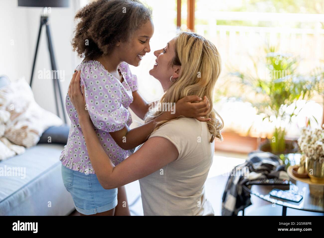 Mother and daughter hugging at home Stock Photo - Alamy