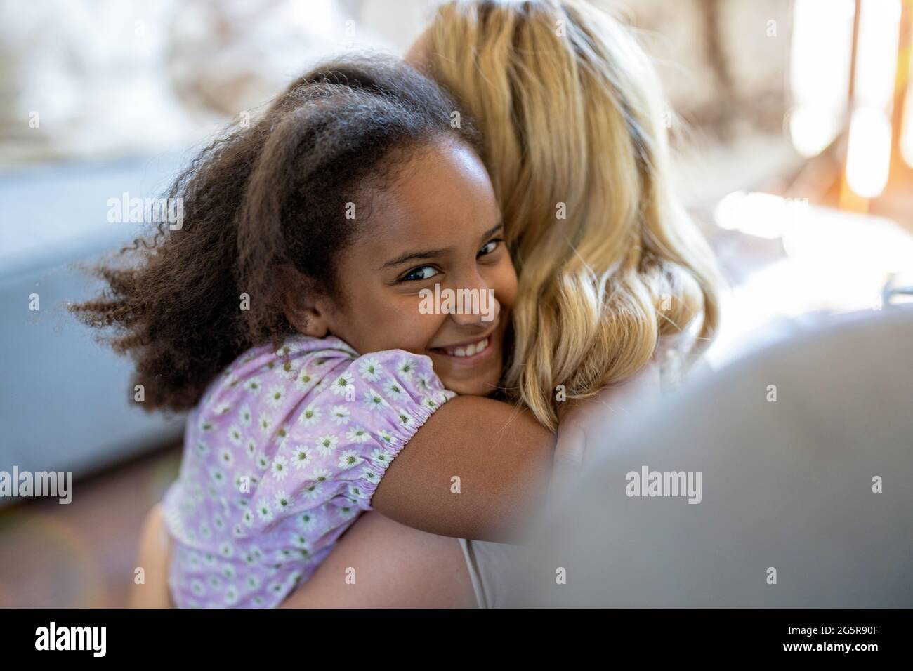 Mother and daughter hugging at home Stock Photo - Alamy