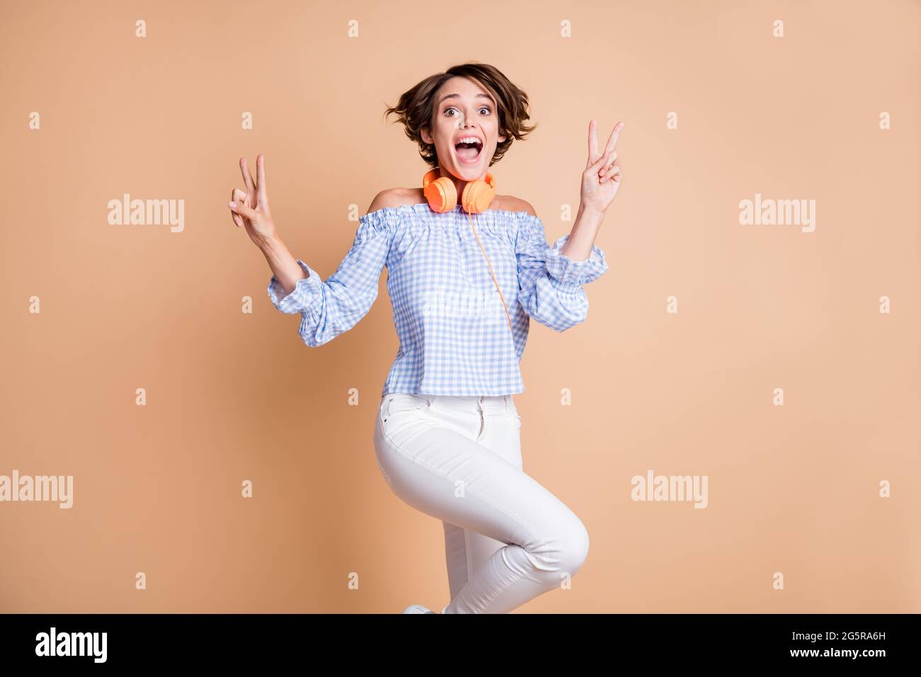 Portrait of lovely amazed cheerful girl showing double v-sign having ...