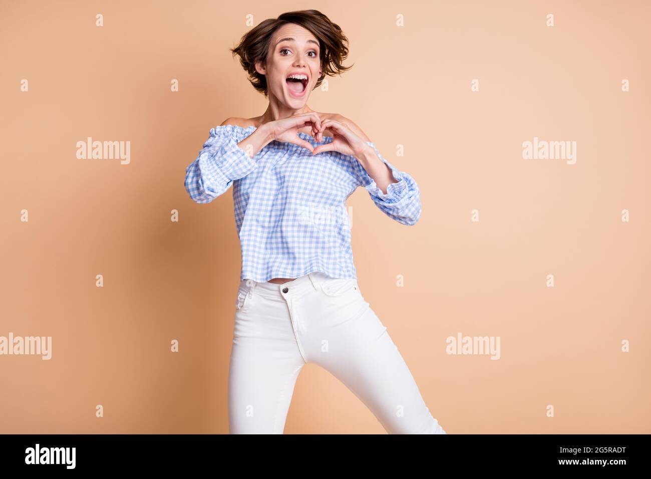 Photo portrait of cute girl showing heart on chest with hands isolated ...