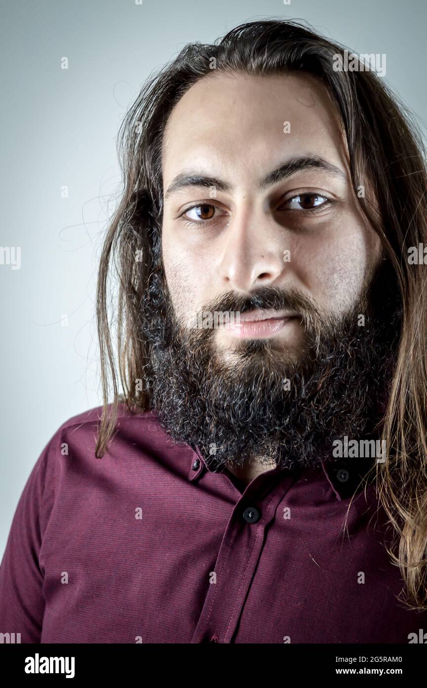 portrait of a young middle eastern businessman with beard and long hair ...