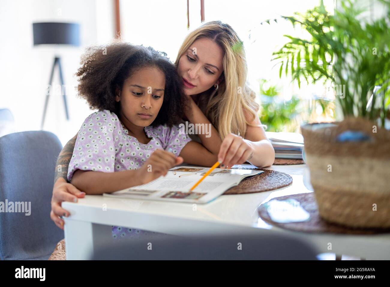 Mother helping daughter with homework Stock Photo - Alamy