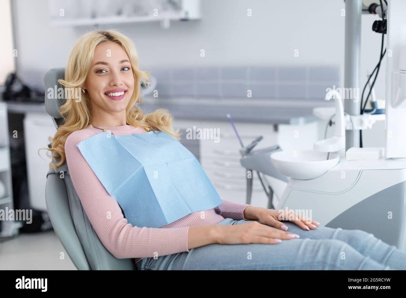 Blonde young woman patient smiling in dentistry, copy space Stock Photo ...