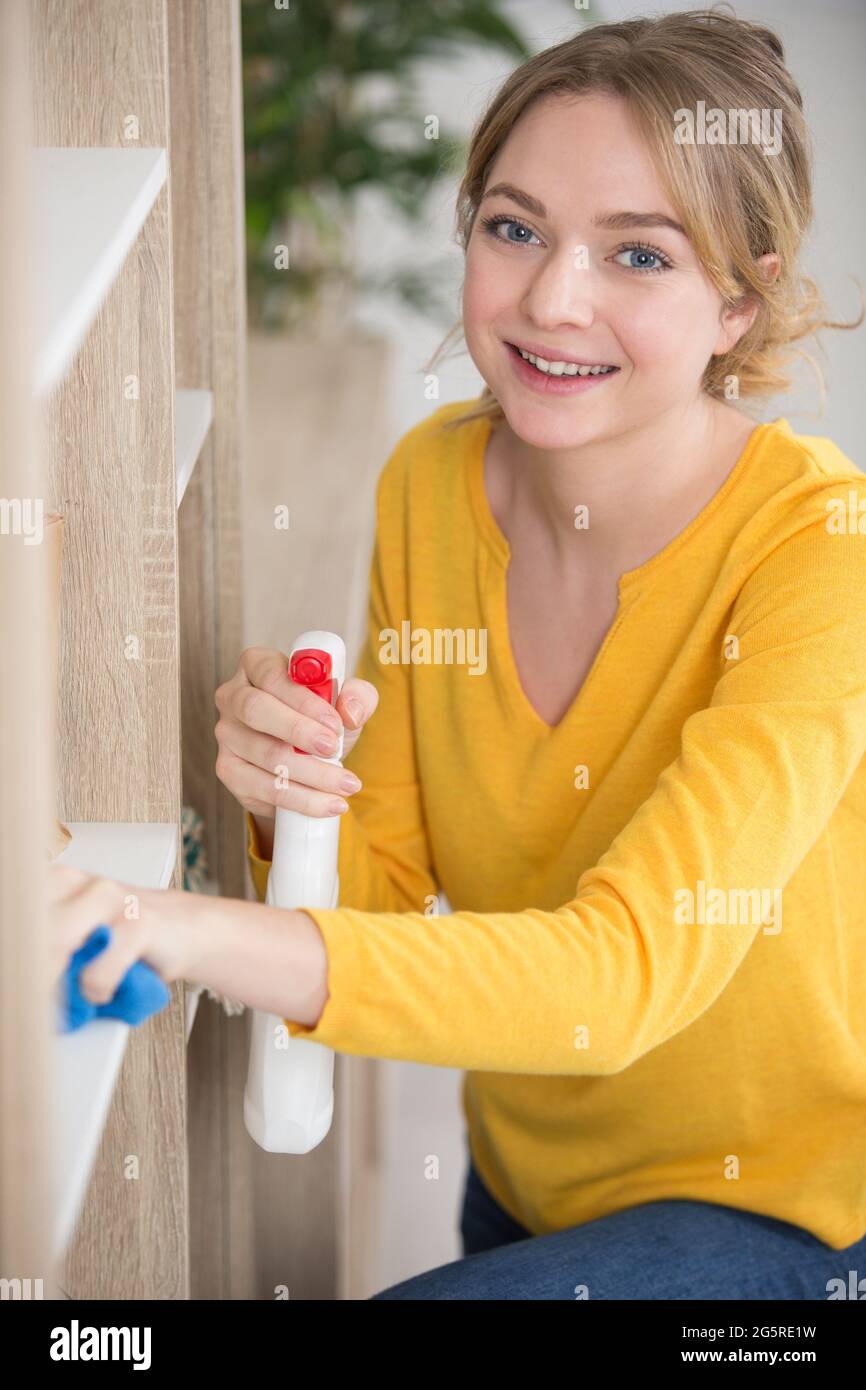 young woman cleaning the wooden shelf in living room Stock Photo - Alamy