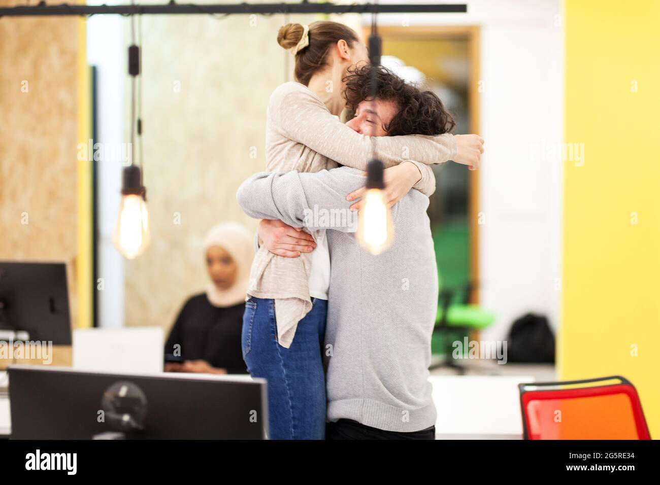Three caucasian colleagues cheering for job well done in a modern ...
