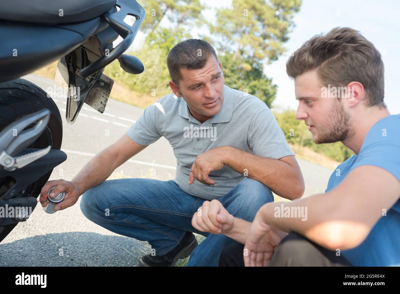 two people with motorcycle problems Stock Photo - Alamy
