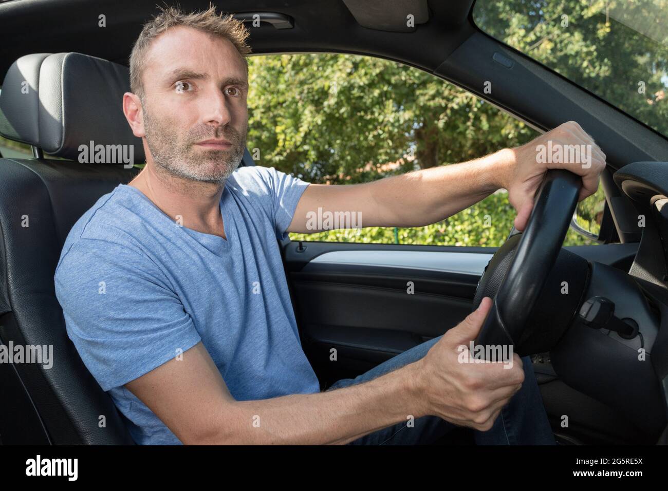 male driver looking seriously in a car Stock Photo - Alamy