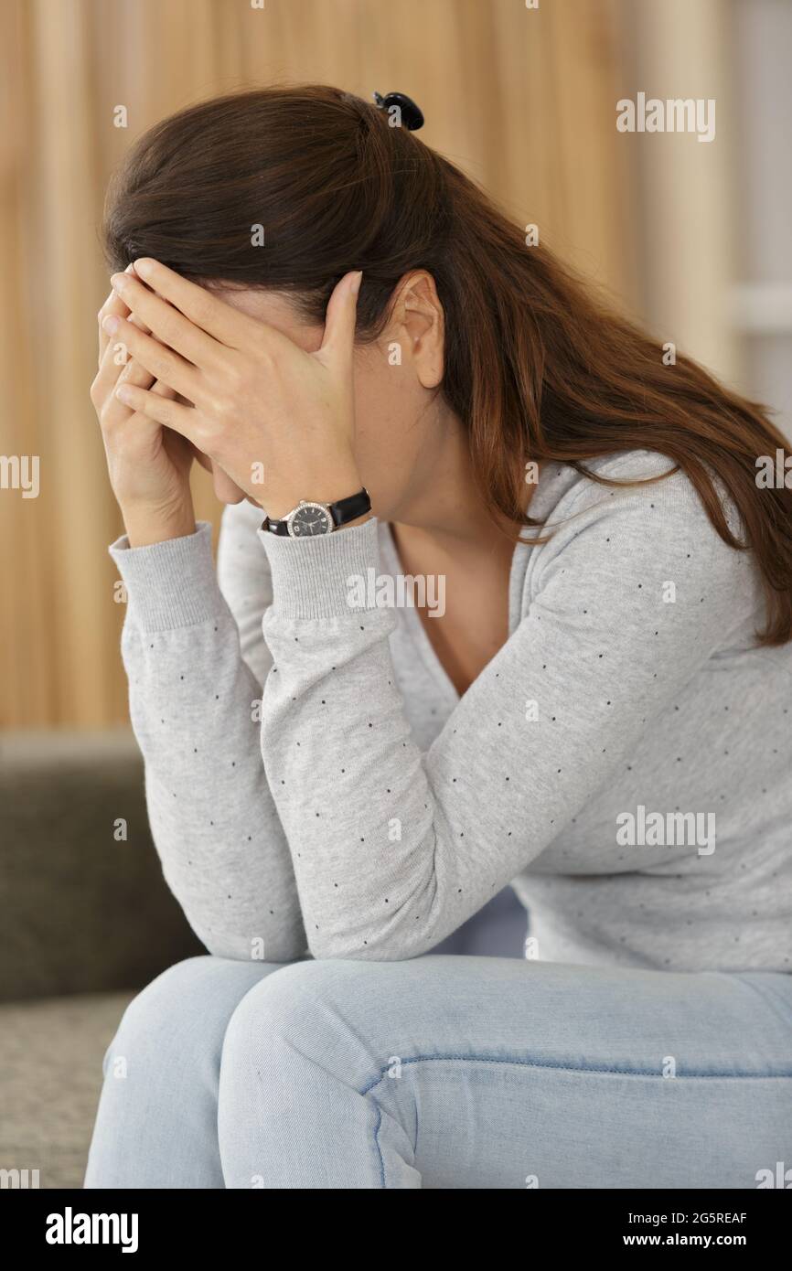a sad woman looking down Stock Photo - Alamy
