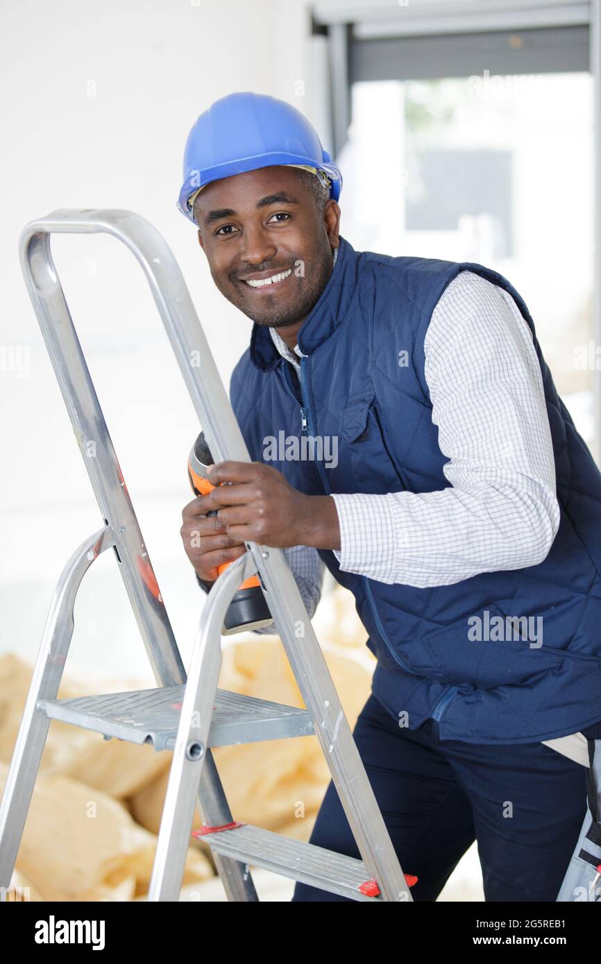 portrait of happy builder on the ladder Stock Photo - Alamy