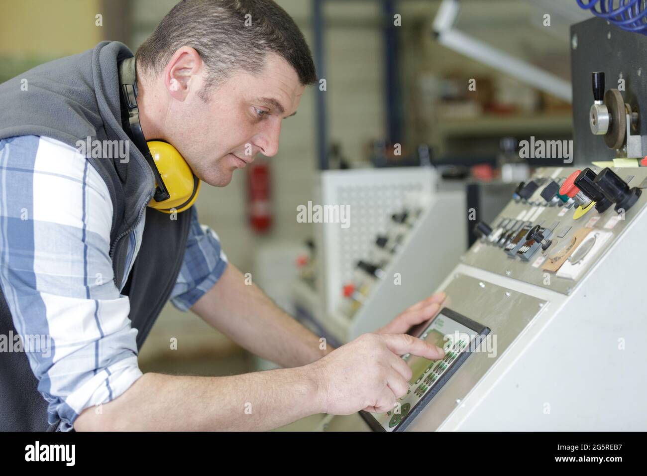 middle aged man operating machine Stock Photo - Alamy