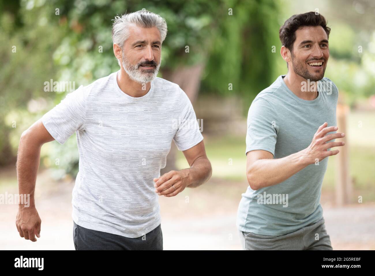 two cheerful men are jogging Stock Photo - Alamy