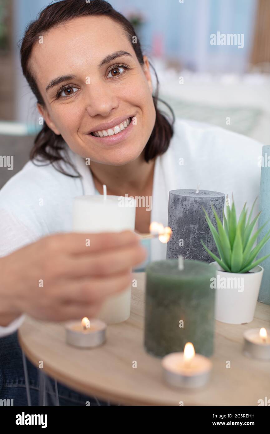 woman lighting atmospheric candles in the home Stock Photo - Alamy