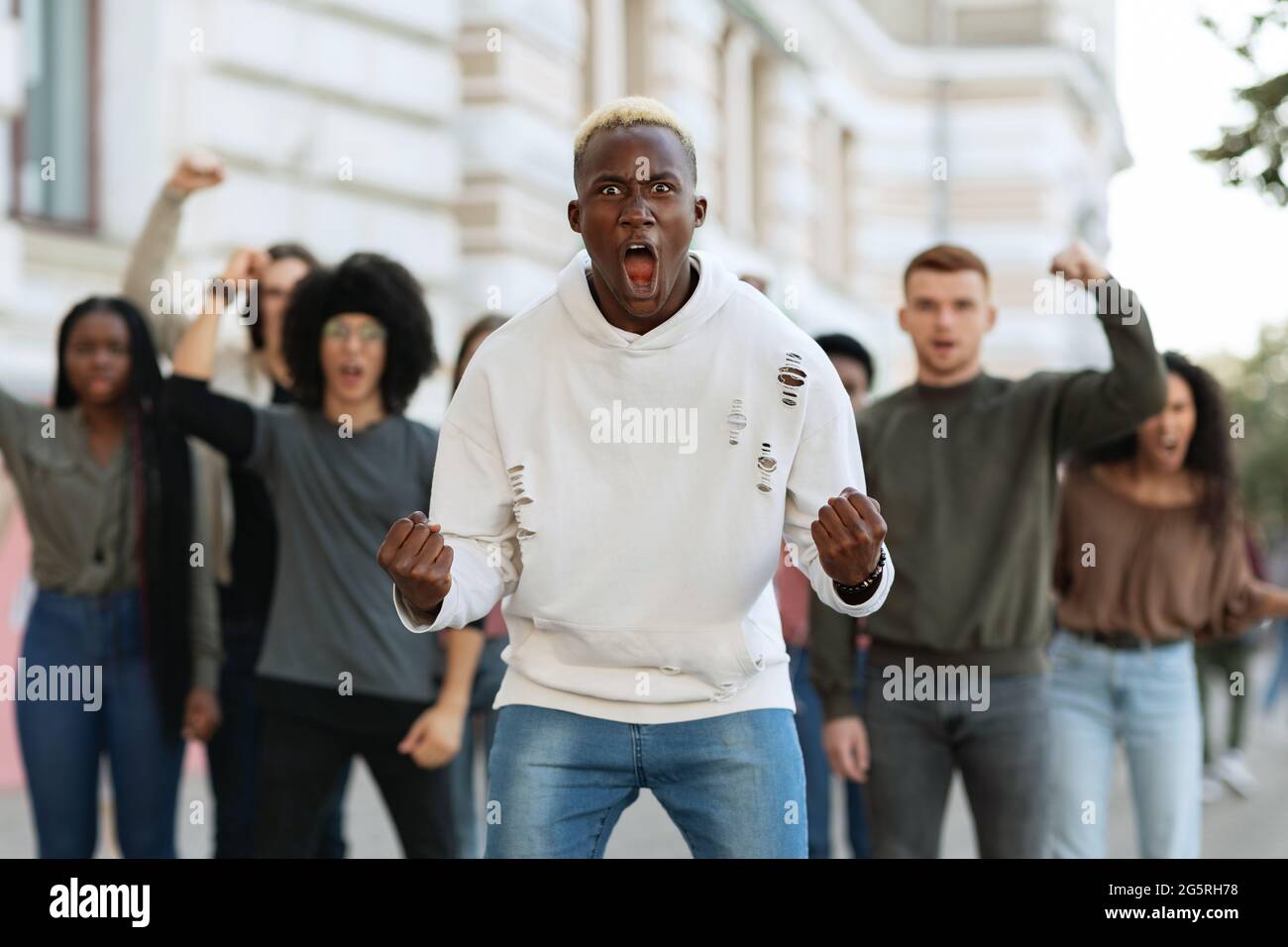 Furious guy leading multiracial activists, making strike on the street ...