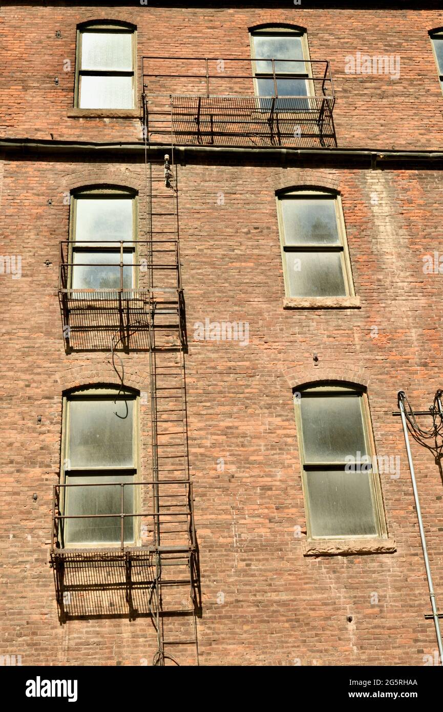 Red Brick Building with Metal Fire Escape, or Fire ladder, with shiny ...