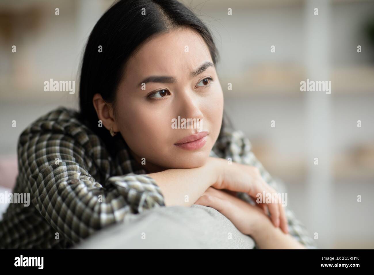 Upset woman sitting on sofa hi-res stock photography and images - Alamy