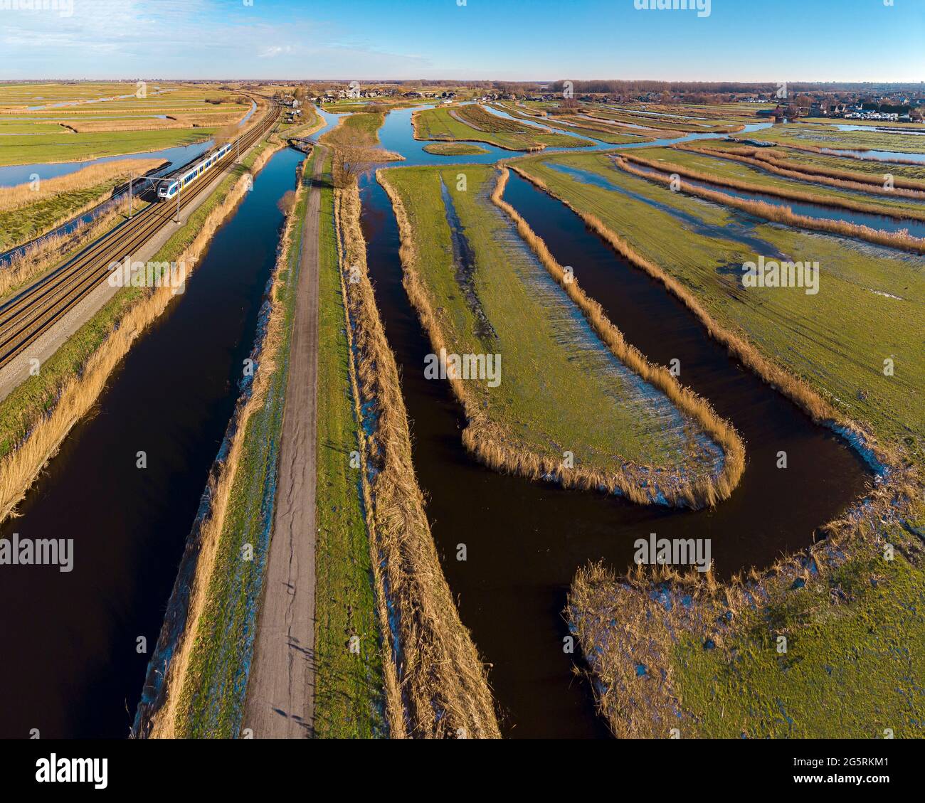 Railway line through an area with lots of canals Stock Photo - Alamy
