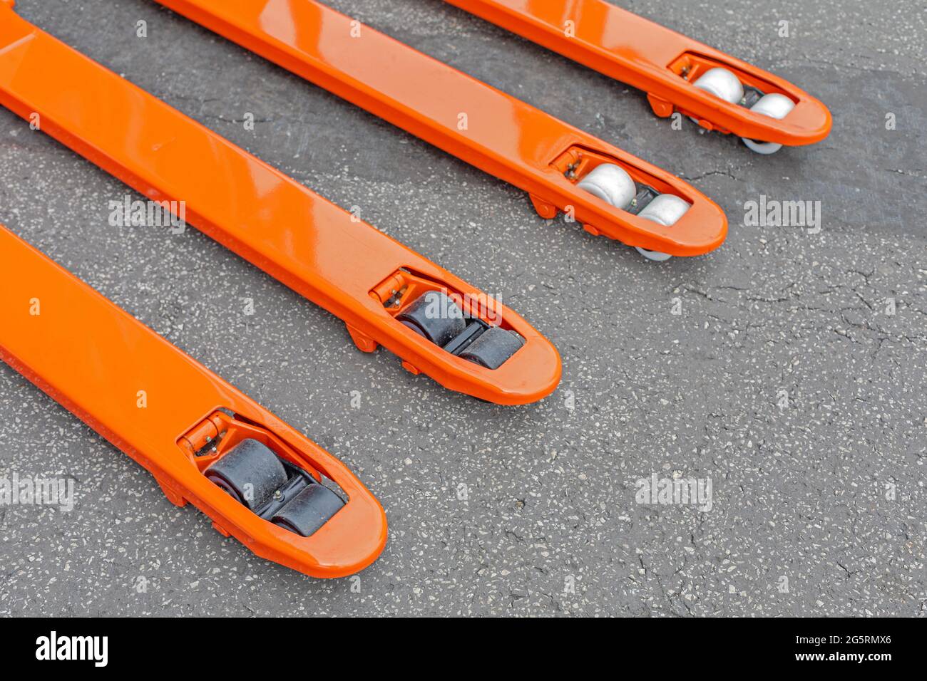 Long Orange Forks With Wheels at Pallet Jack Stock Photo - Alamy