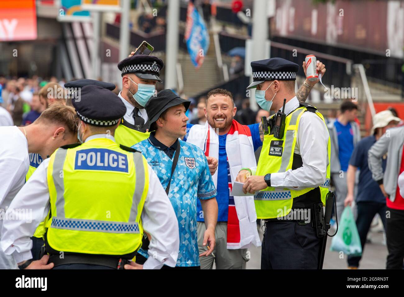 Police stop a fan after he had let off a flare outside Wembley Stadium ...