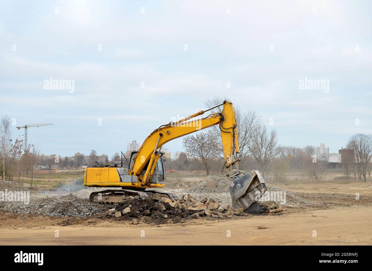Excavator with crusher bucket for crushing concrete. Construction waste ...