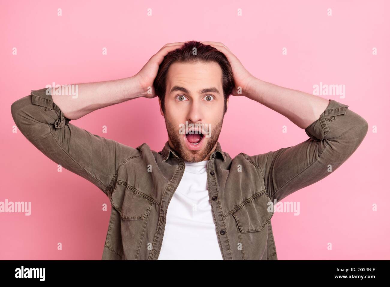 Photo of young man amazed shocked surprised hands touch head afraid ...