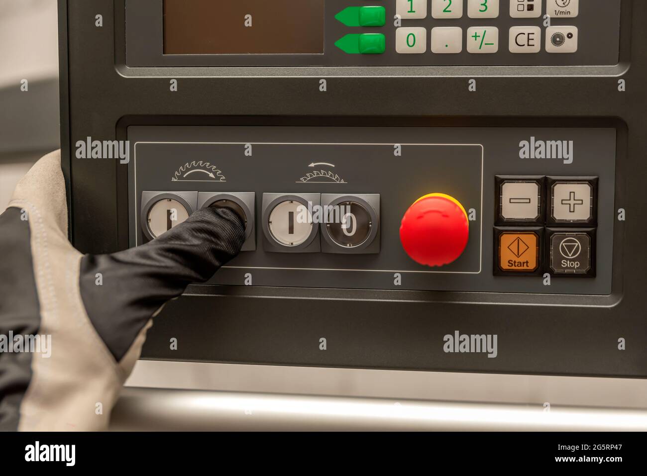 Hand presses the power button of a woodworking machine at a factory ...