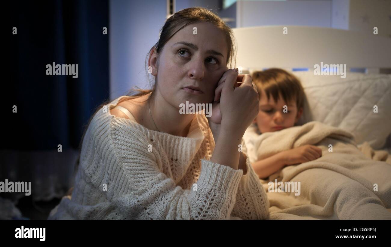 Young woman crying at bed of her sick son at night Stock Photo - Alamy