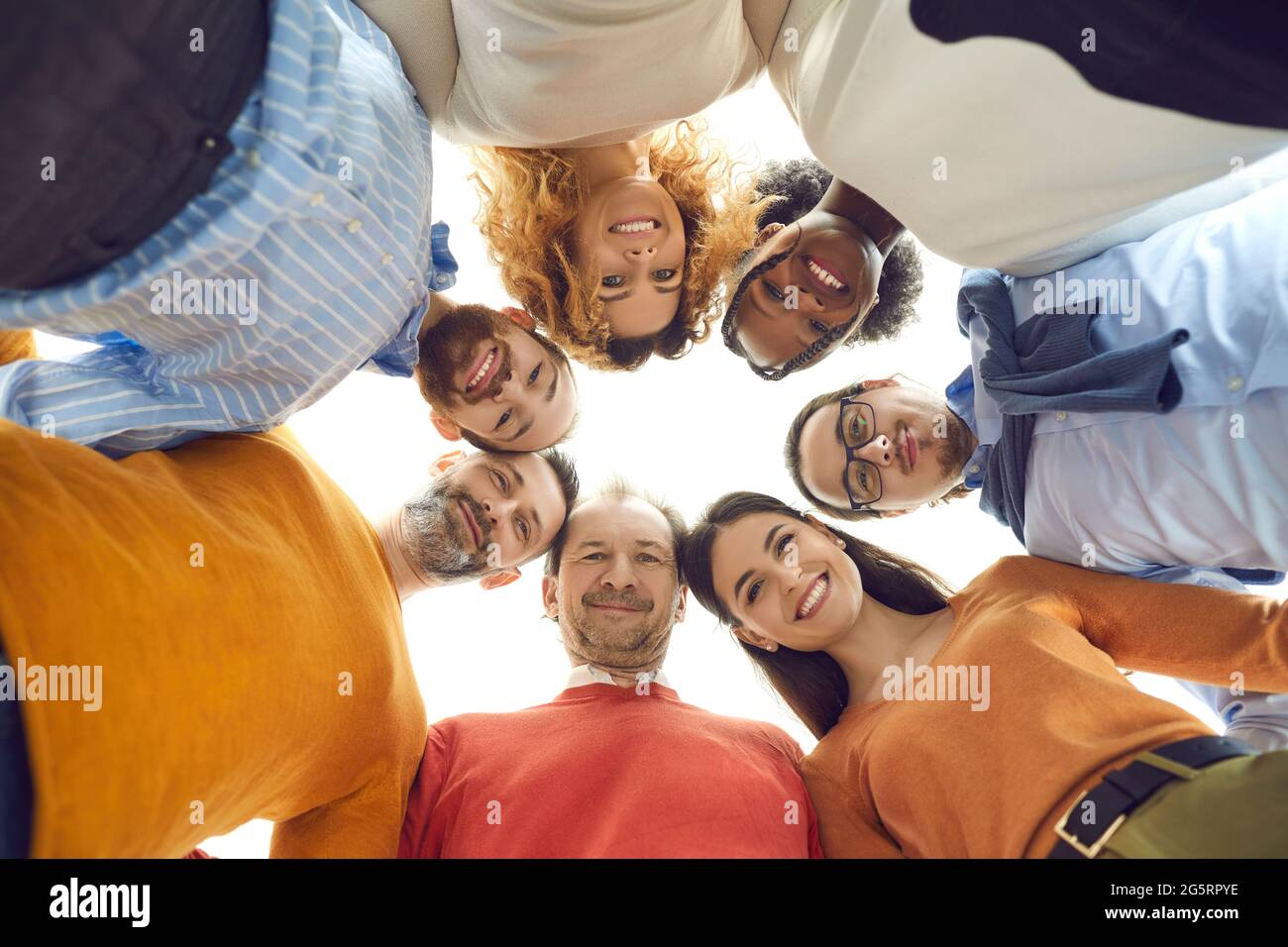 Low angle portrait of diverse team of happy people huddling in ...