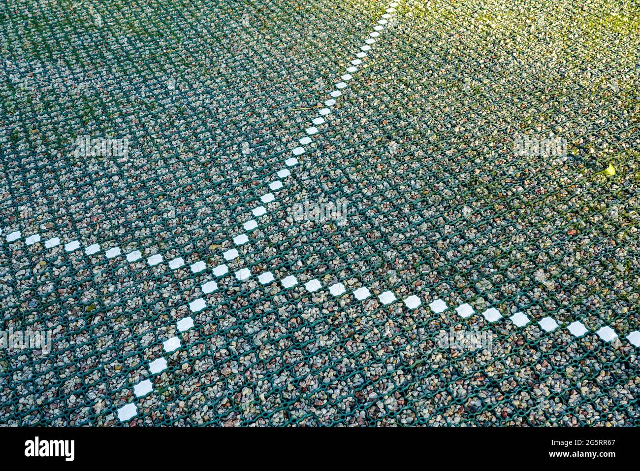 new modern car park gravel base with installed green plastic grid and ...