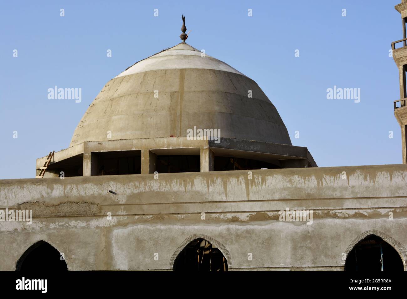 A new mosque under construction against the sunny blue sky with the ...