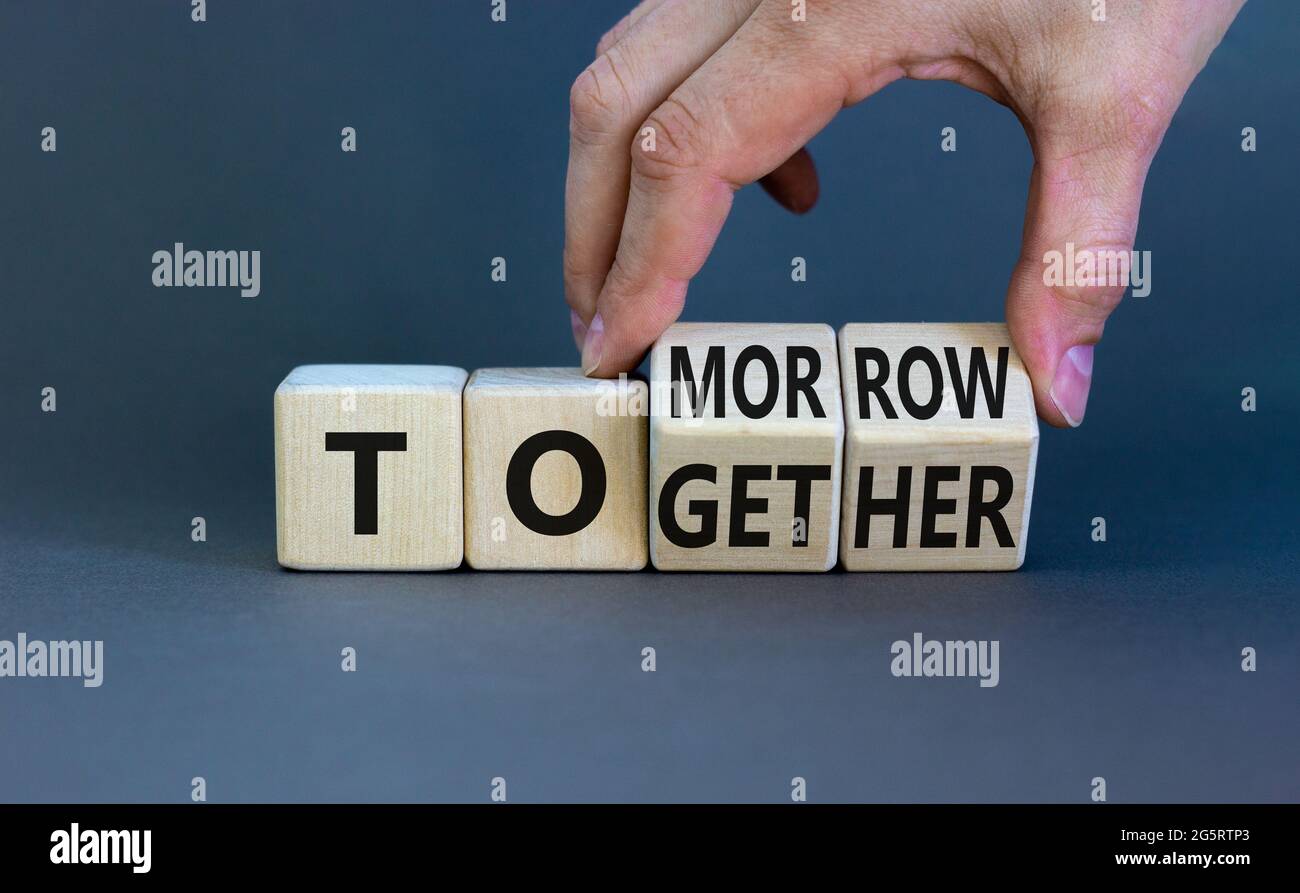 Tomorrow we will together symbol. Businessman turns wooden cubes and ...