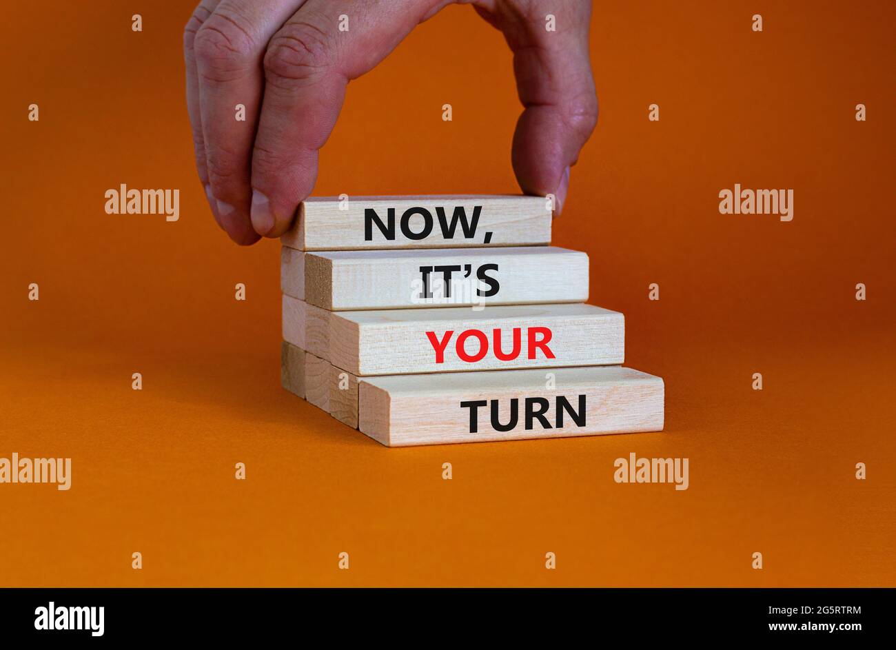 Now, it's your turn symbol. Wooden blocks form the words 'now, it's ...