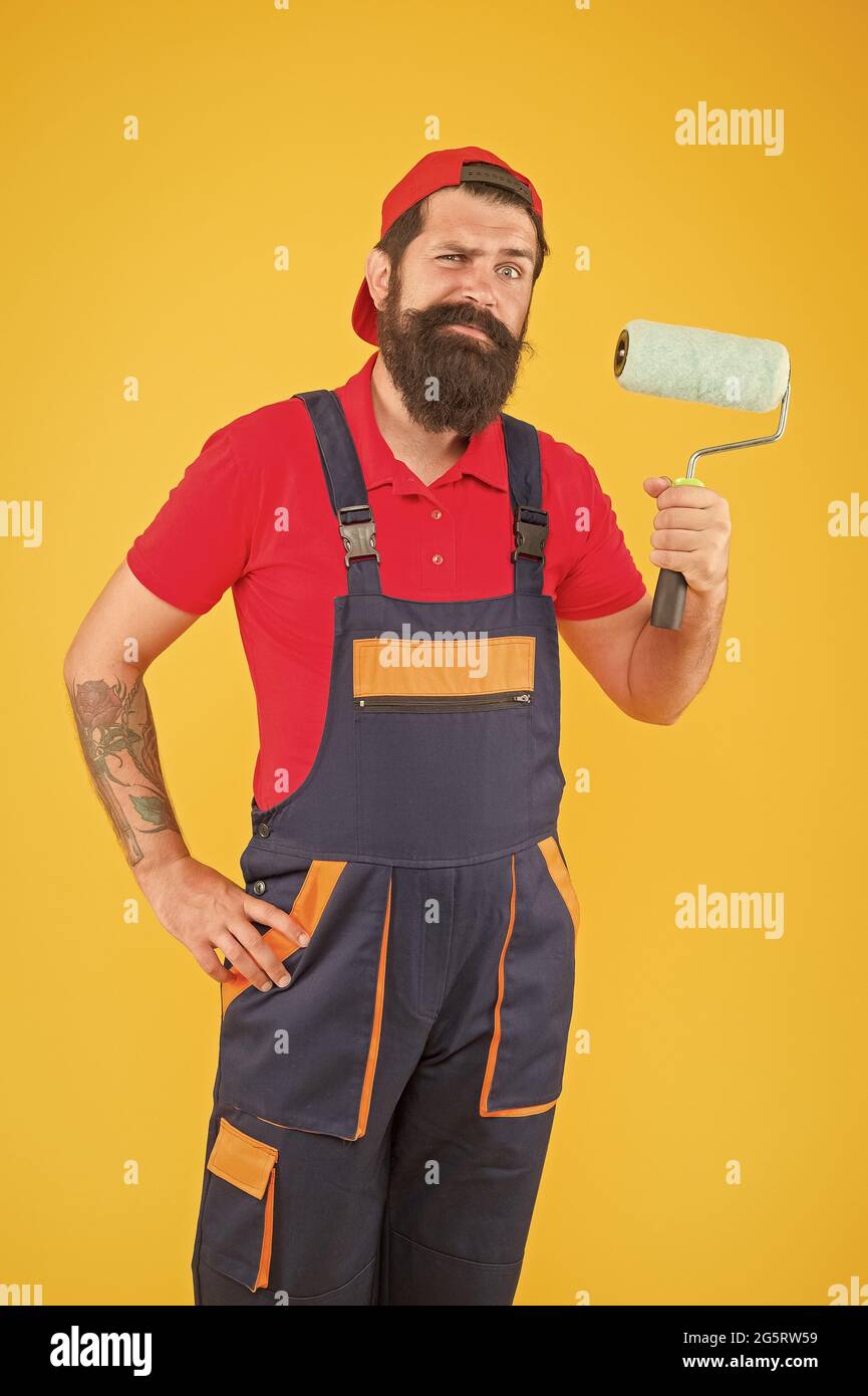brutal bearded man painter worker in boiler suit uniform using paint ...
