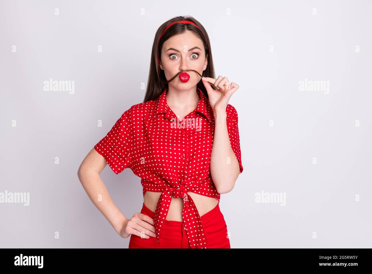 Portrait of attractive humorous funky girl making fake mustache fooling ...