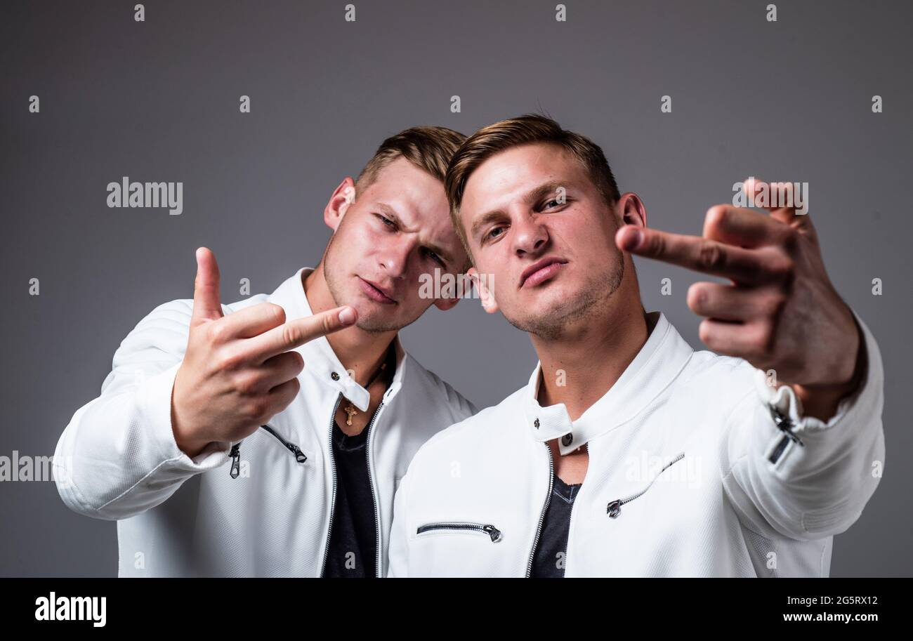 twin brothers men in white casual clothes look alike show middle finger ...