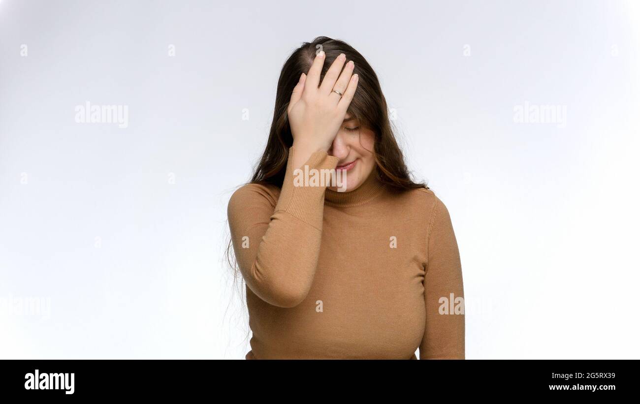 Studio portrait of disappointed young woman making facepalm gesture ...
