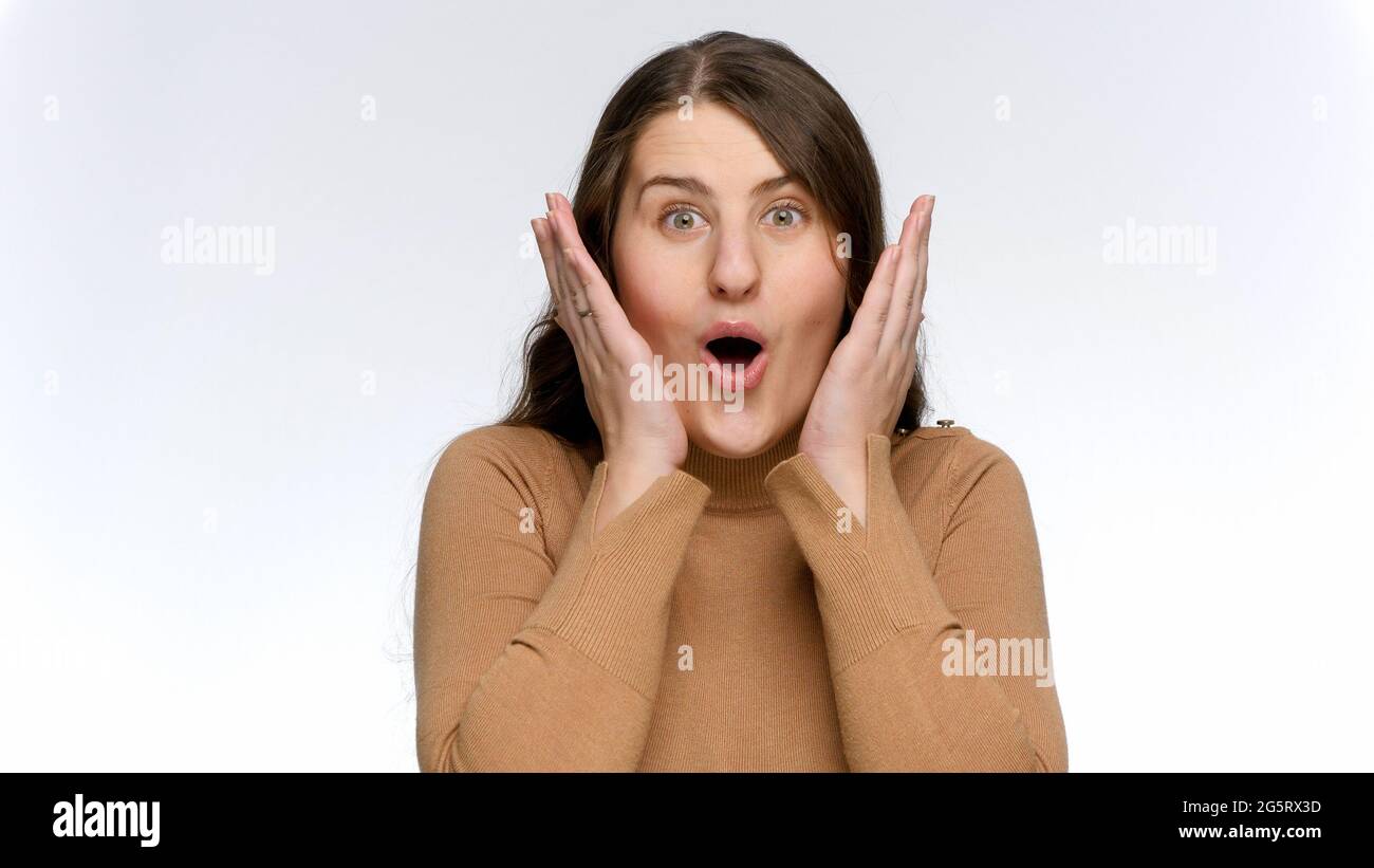 Beautiful cute woman gets surprised and shakes head. Positive emotions ...