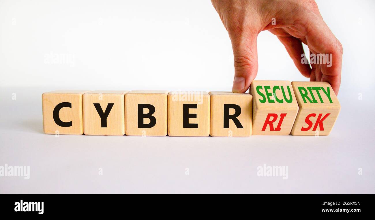 Cyber-security vs cyber-risk symbol. Businessman turns wooden cubes ...