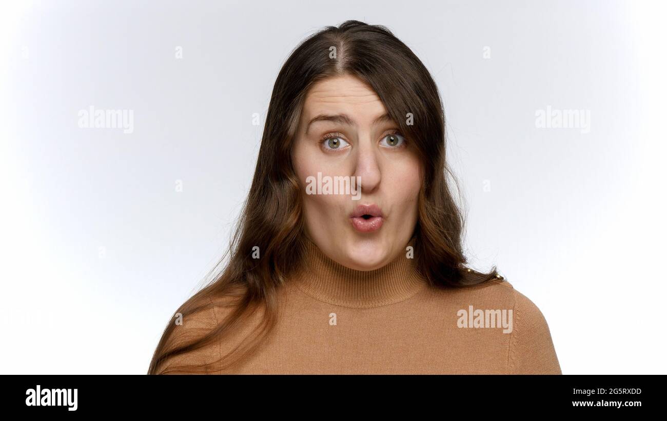 Studio portrait of amazed woman opens widely eyes and mouth. Shock and ...