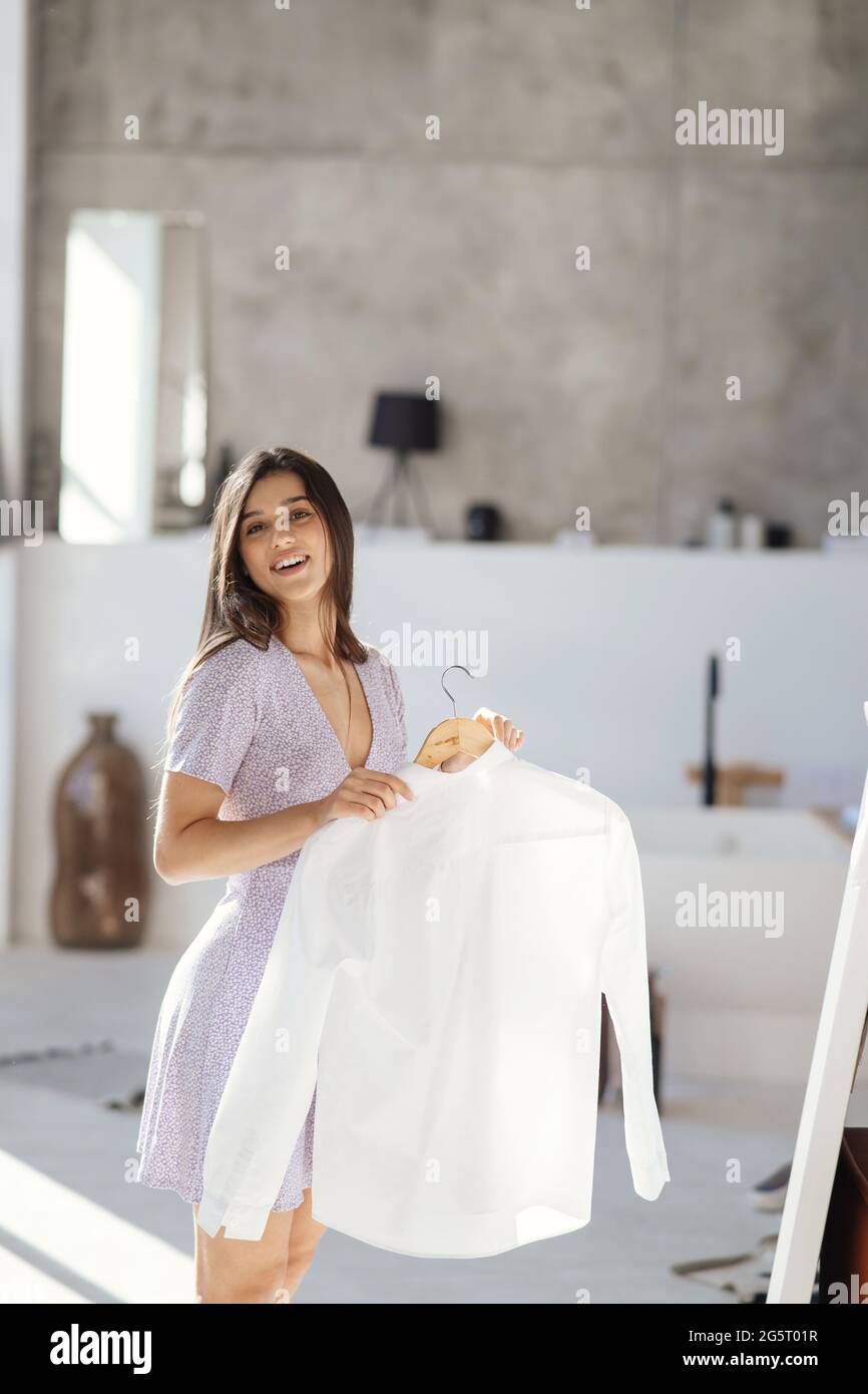 Beautiful girl trying dress in room Stock Photo - Alamy