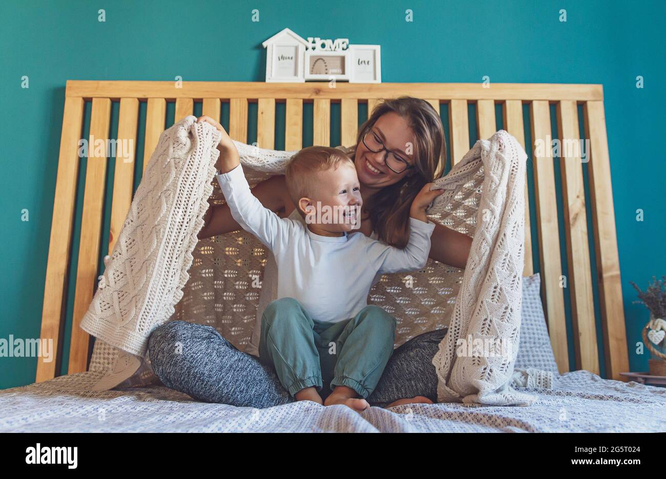 mom and child have fun in the bedroom on the bed under the blank Stock ...