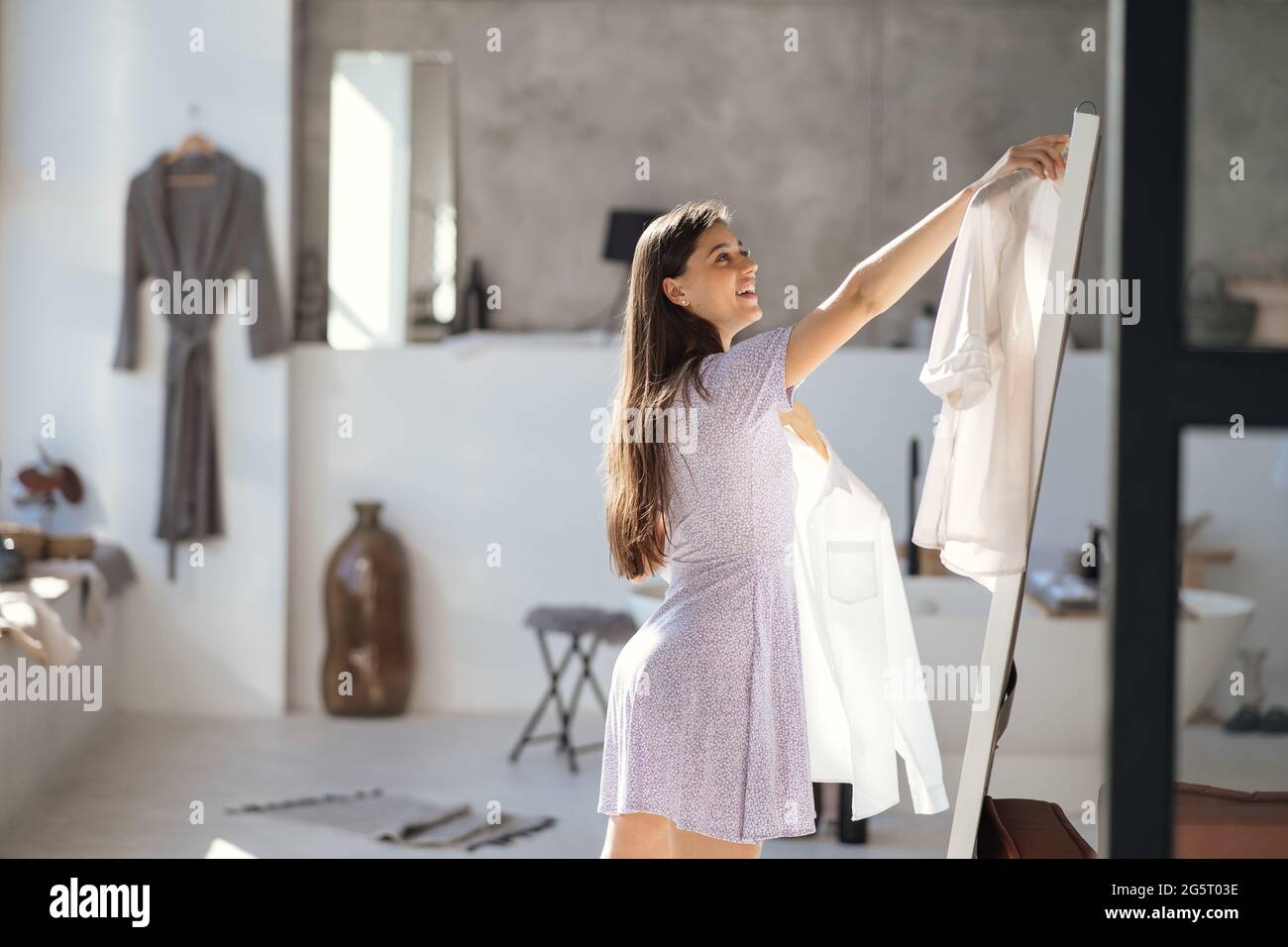Beautiful girl trying dress in room Stock Photo - Alamy