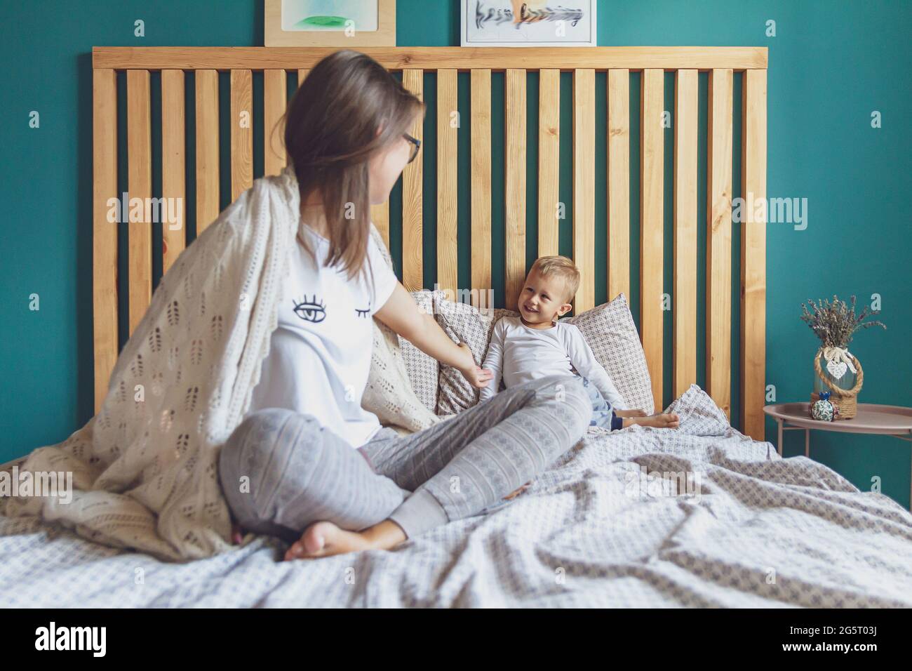mom and child have fun in the bedroom on the bed under the blank Stock ...