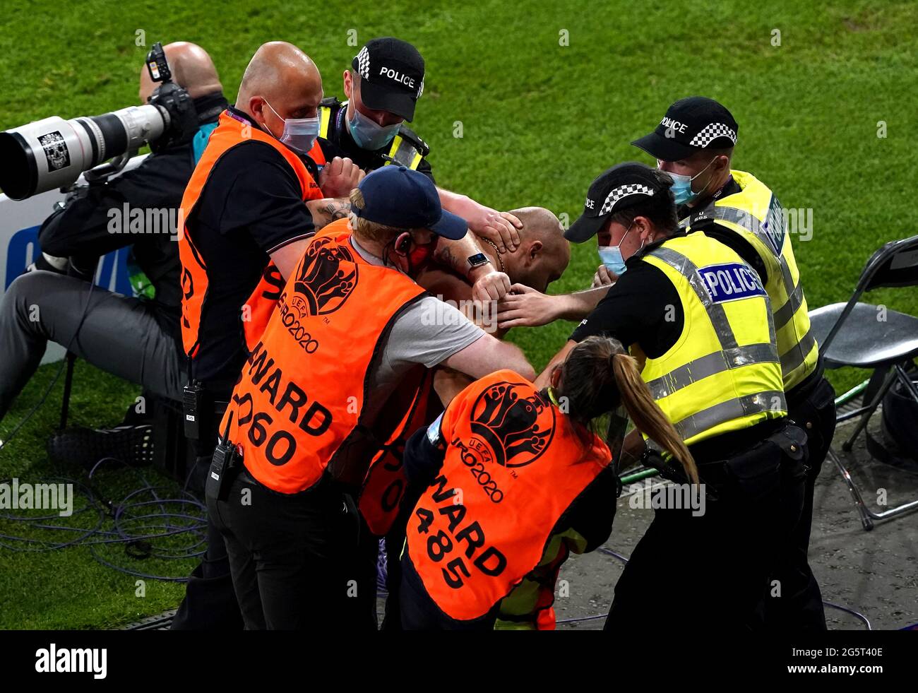 A pitch invader is removed by security and police during the UEFA Euro ...