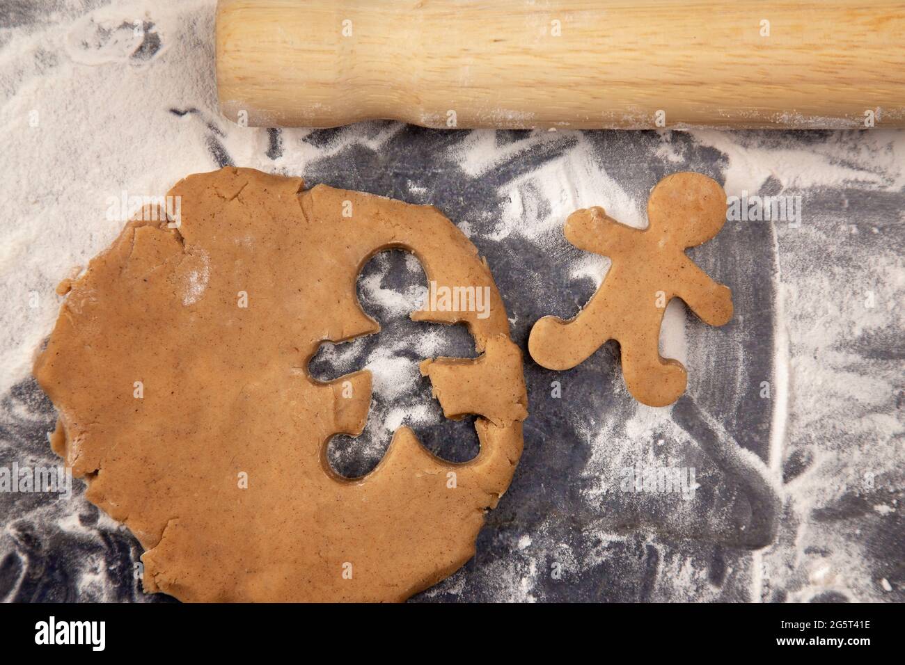 Gingerbread Cookies Being Rolled Out and Cut into People Stock Photo ...