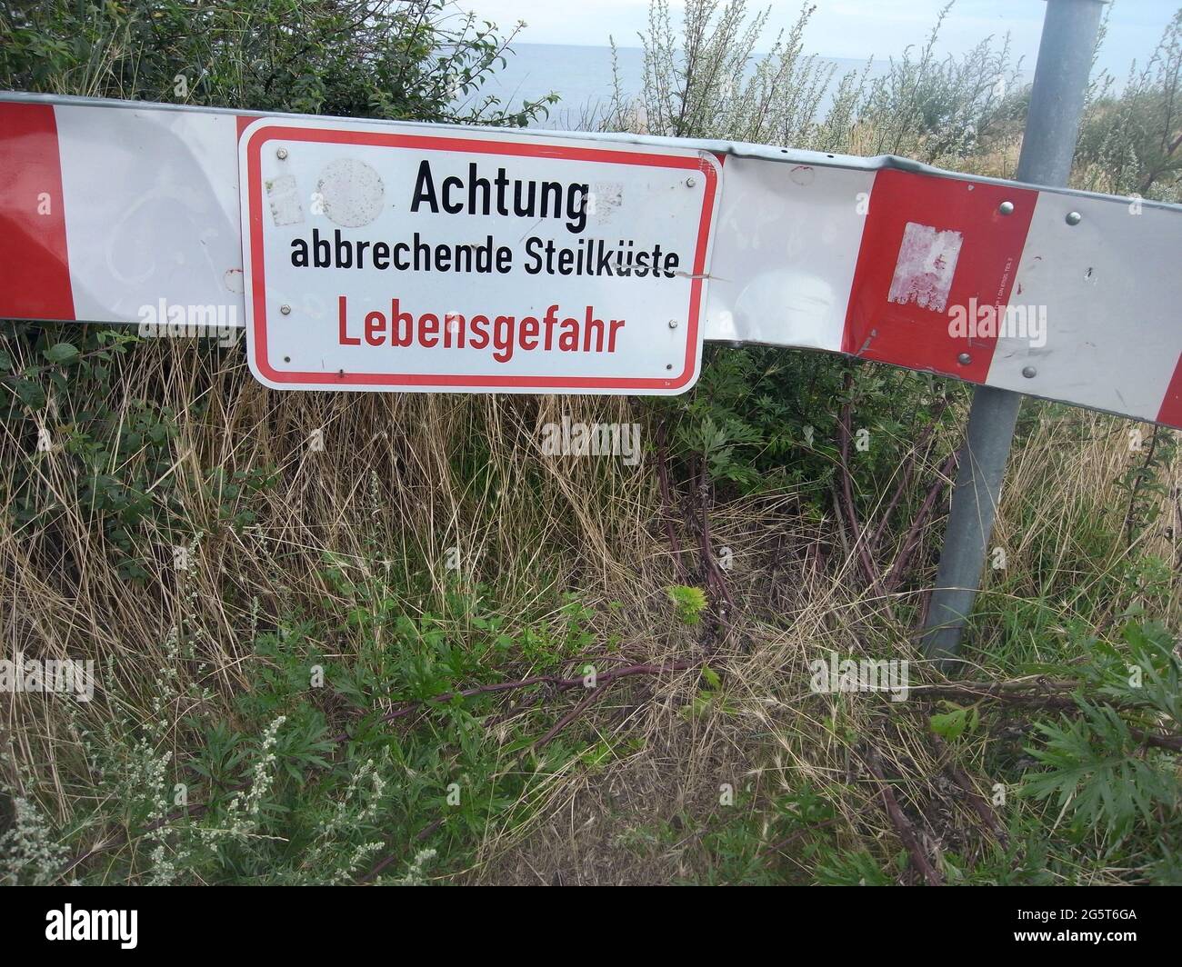 warning sign and barrier at the Coast of the Baltic Sea; danger of ...
