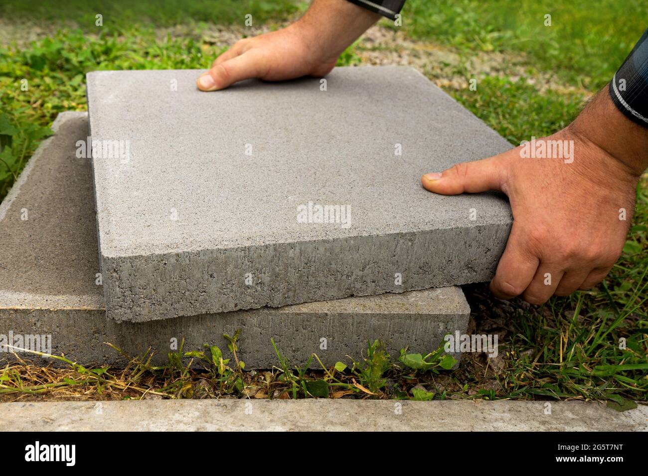 Large heavy paving slabs being laid by a man Stock Photo - Alamy